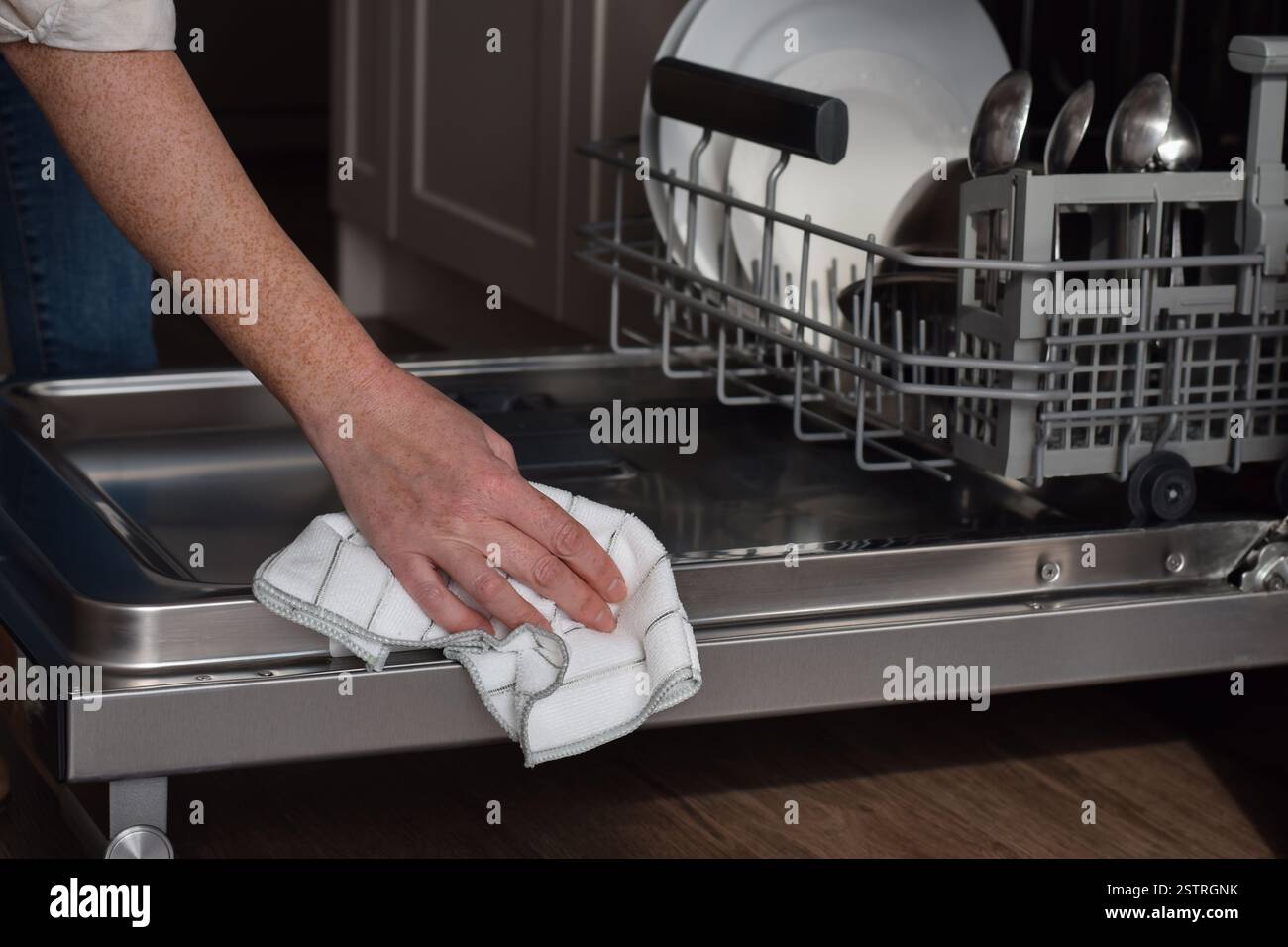 Woman cleaning sides of dishwasher door with dish cloth Stock Photo - Alamy