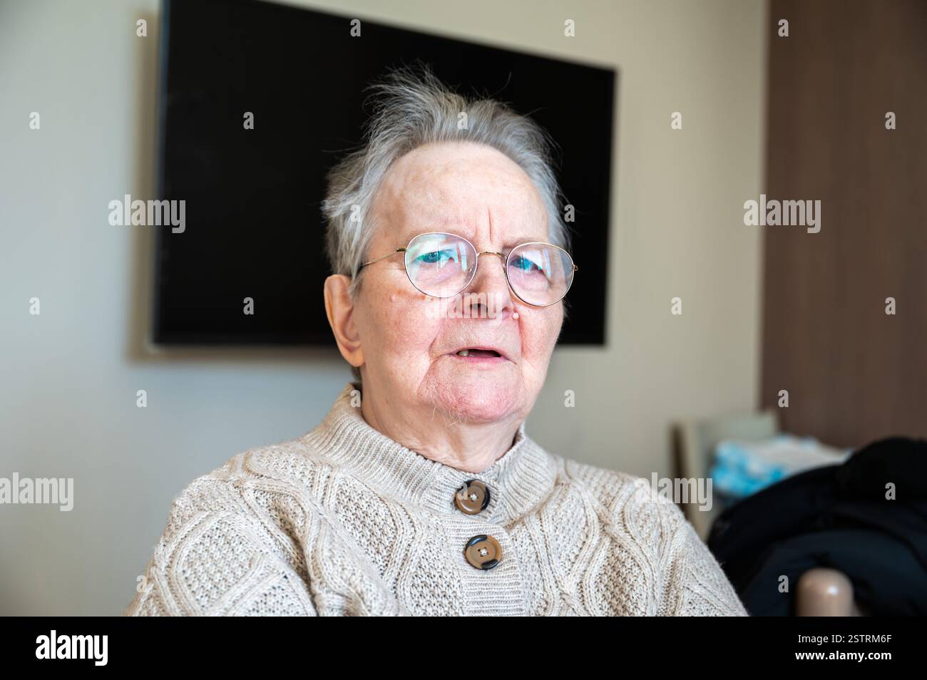 Expressive portrait of an 86 yo grandmother sitting in a wheelchair ...