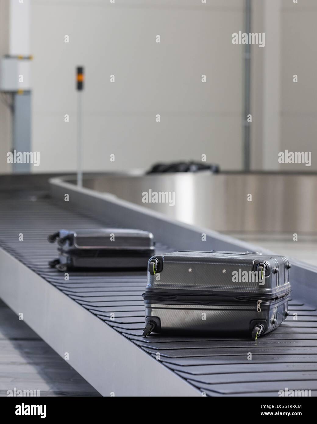 Baggage claim at an airport, two suitcases on a conveyor belt at an ...