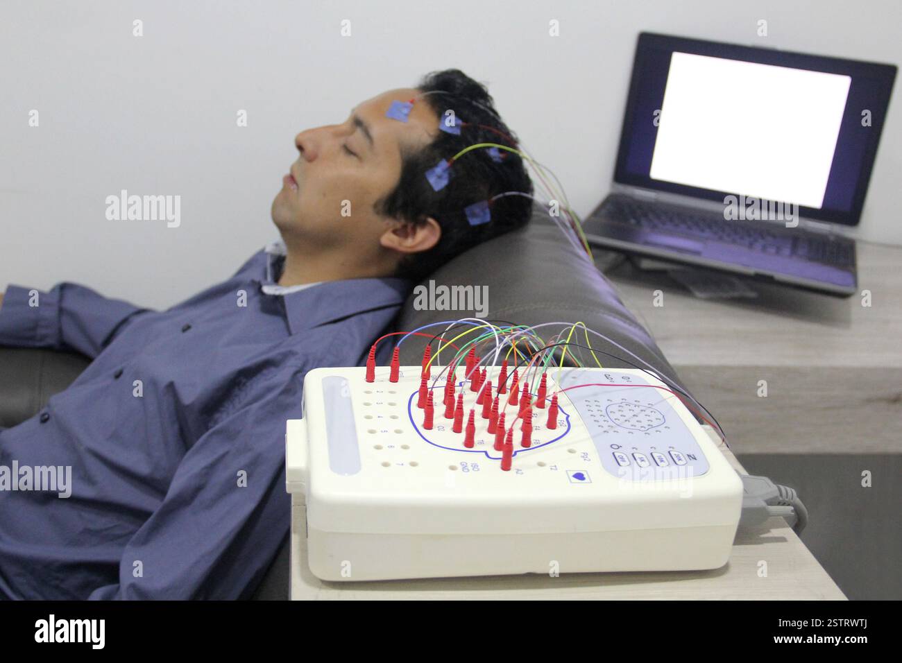 Electroencephalogram EEG in adult Latino man with wires in his head ...