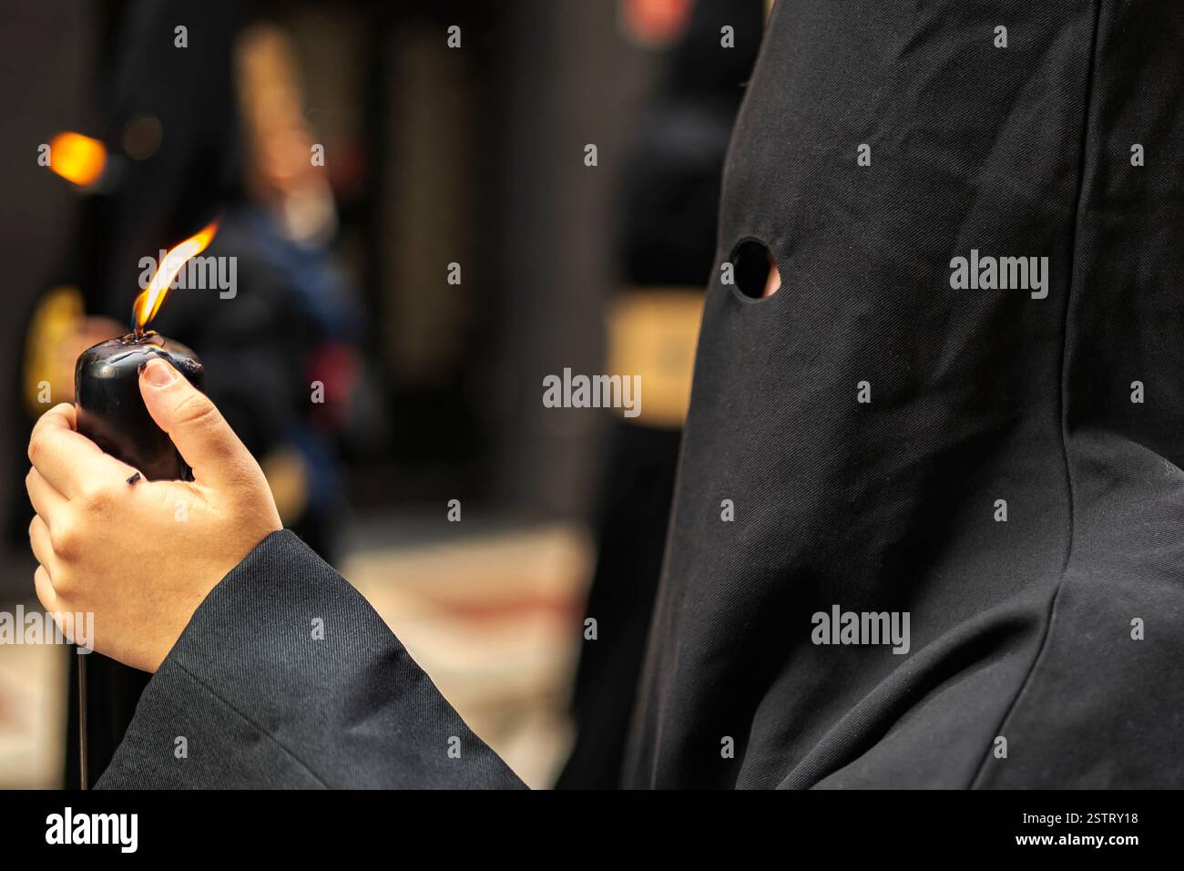 Close-up of a Nazarene dressed in black tunic, captured in profile ...