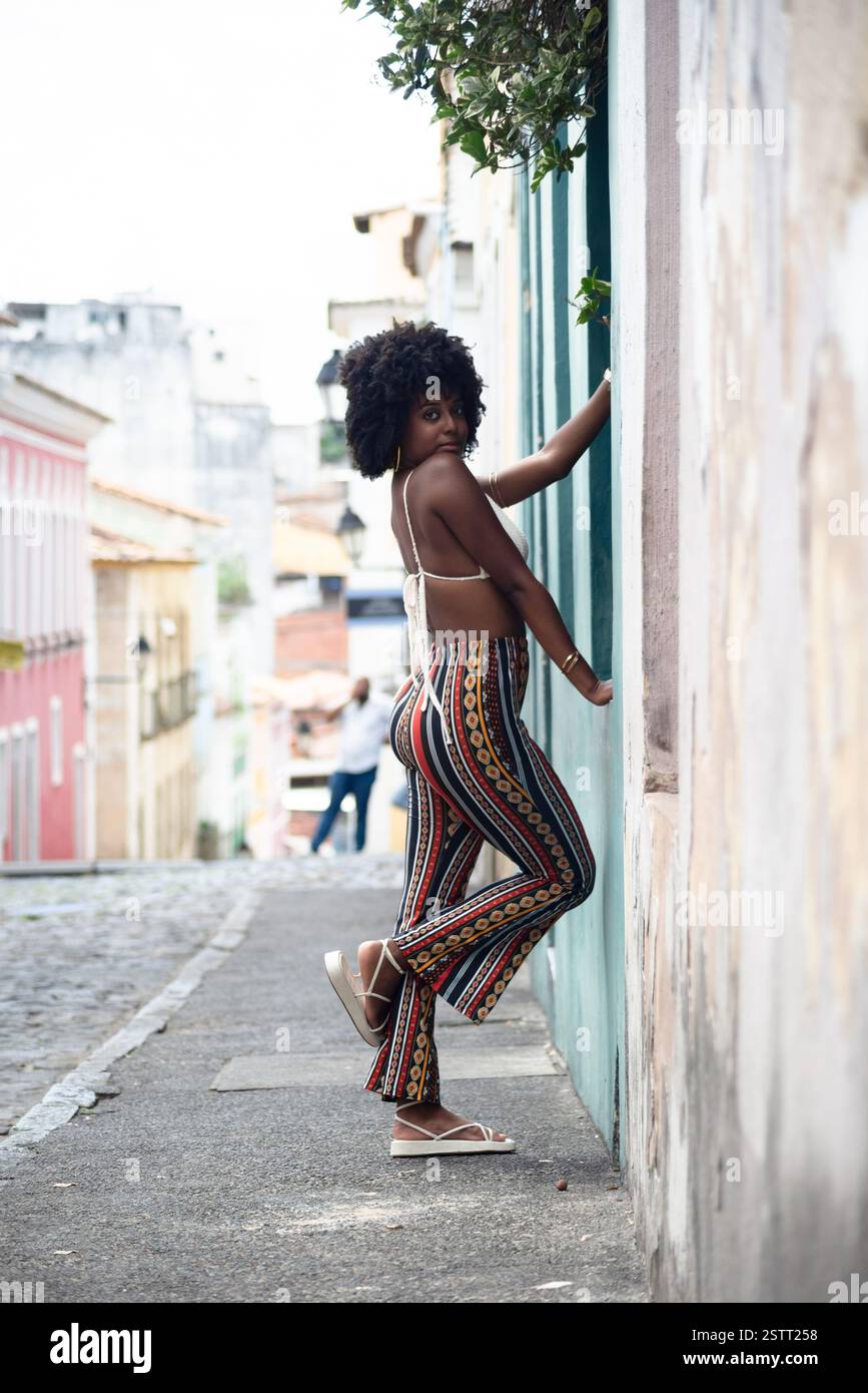 Full body shot of beautiful woman leaning against an old wall posing ...