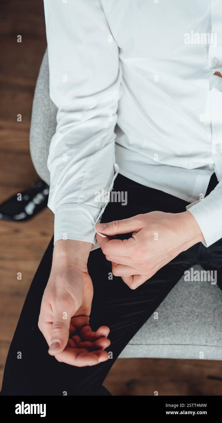 The process of fastening the buttons on his white shirt Stock Photo - Alamy