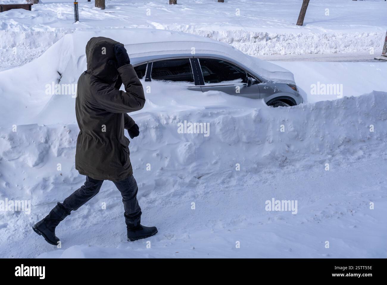 Montreal, Canada - 19 February 2025: Man walking on a sidewalk covered ...