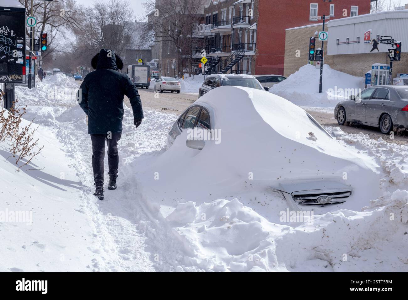Montreal, Canada - 19 February 2025: Man walking on a sidewalk covered ...