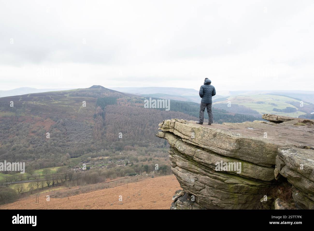 A hiker enjoying the dramatic view from Bamford Edge in the Peak ...