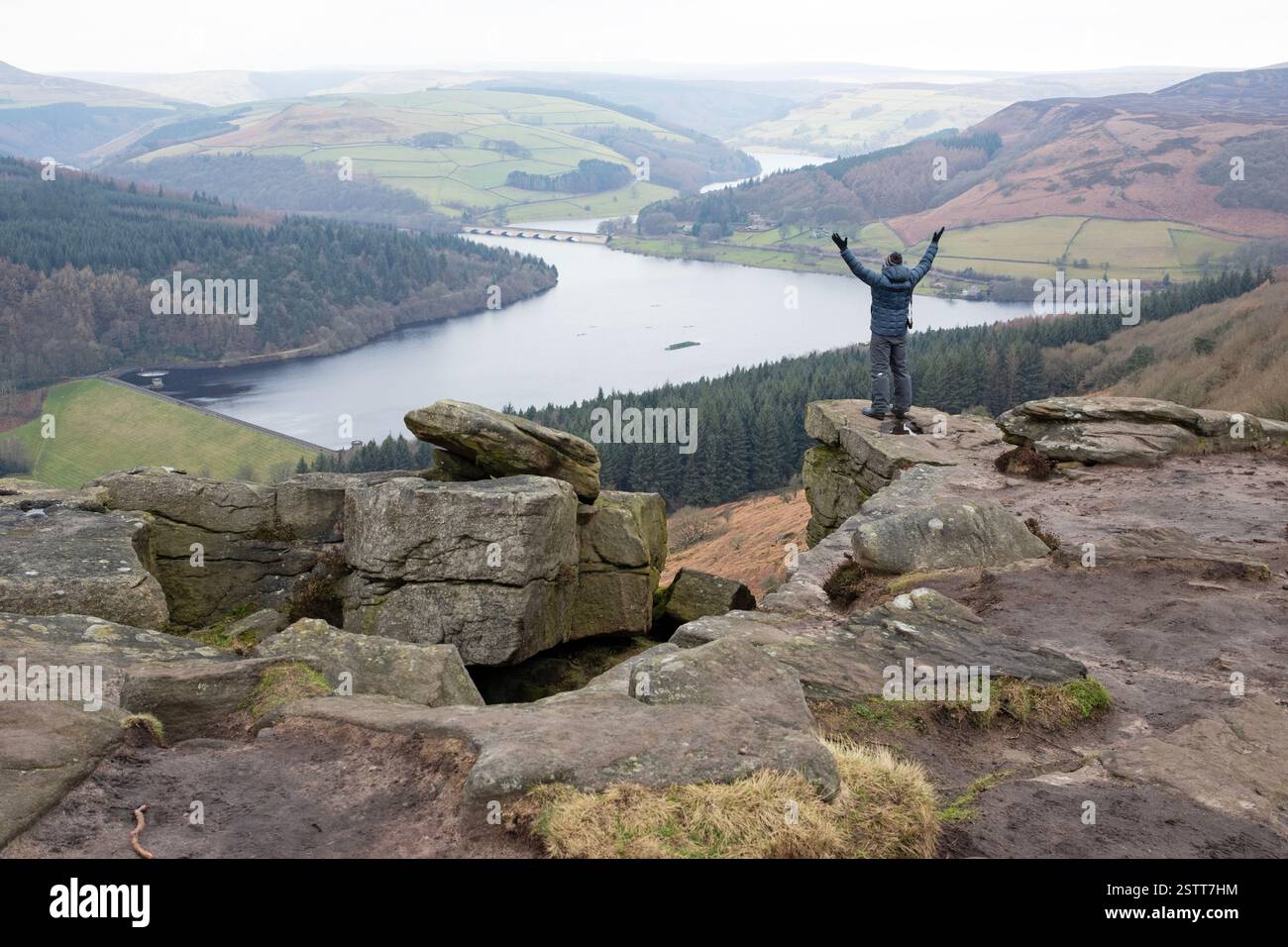 A hiker enjoying the dramatic view from Bamford Edge in the Peak ...