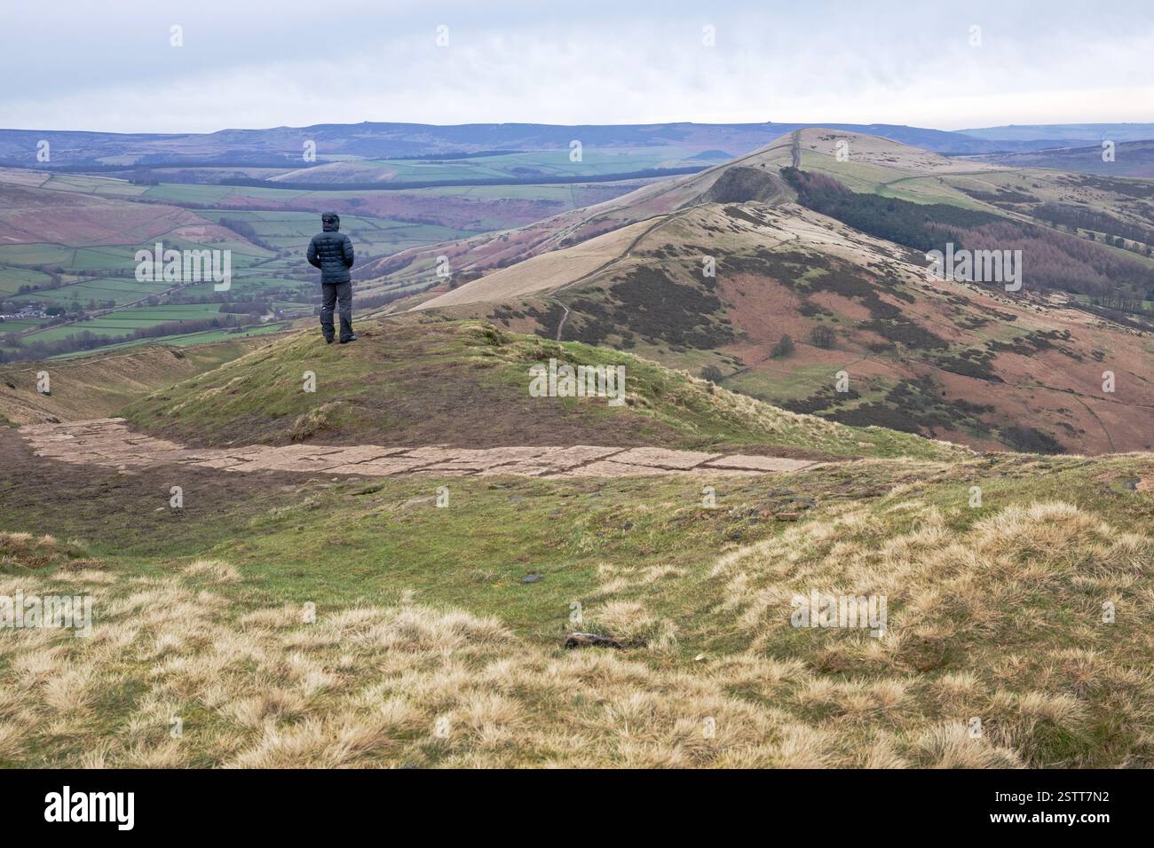 A hiker admires the view of the Mam Tor mountain range in the Peak ...