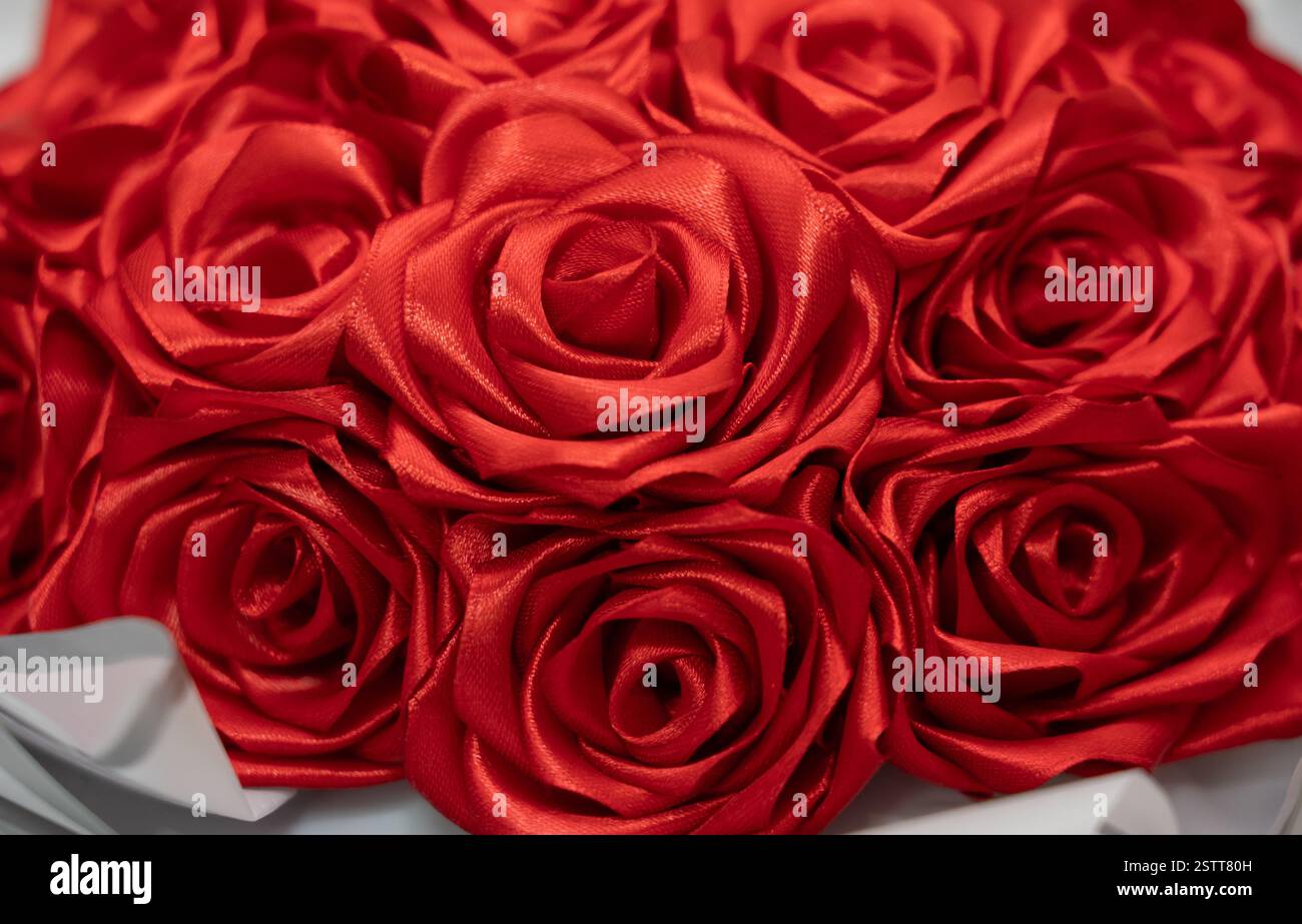 Vibrant red silk roses are meticulously arranged in a circular ...