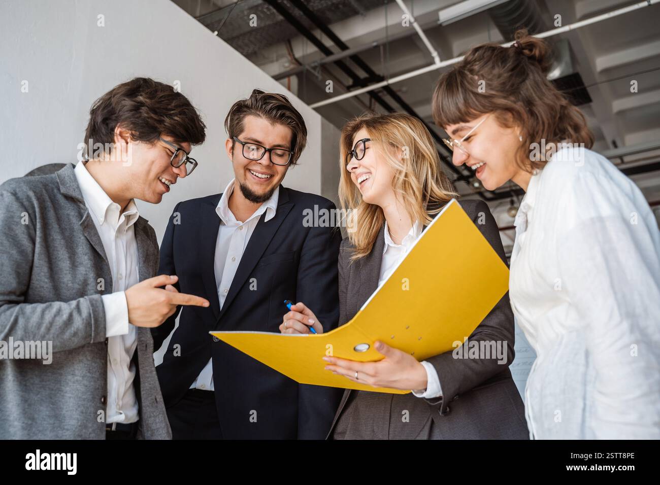 Group of inspired young people standing and discussing new project ...