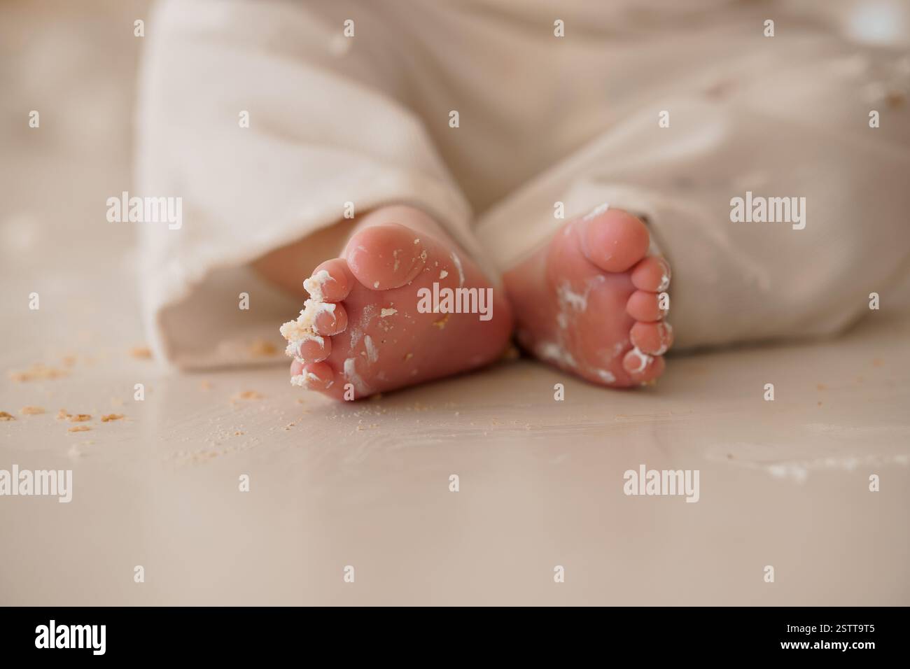 Cute Baby Feet Covered in Messy Cake Icing on a White Surface Stock ...