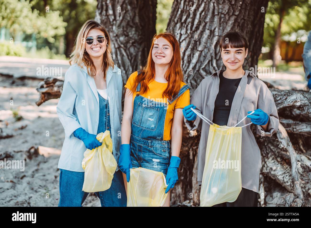 Friends picking up trash from the park. They collecting the litter in ...