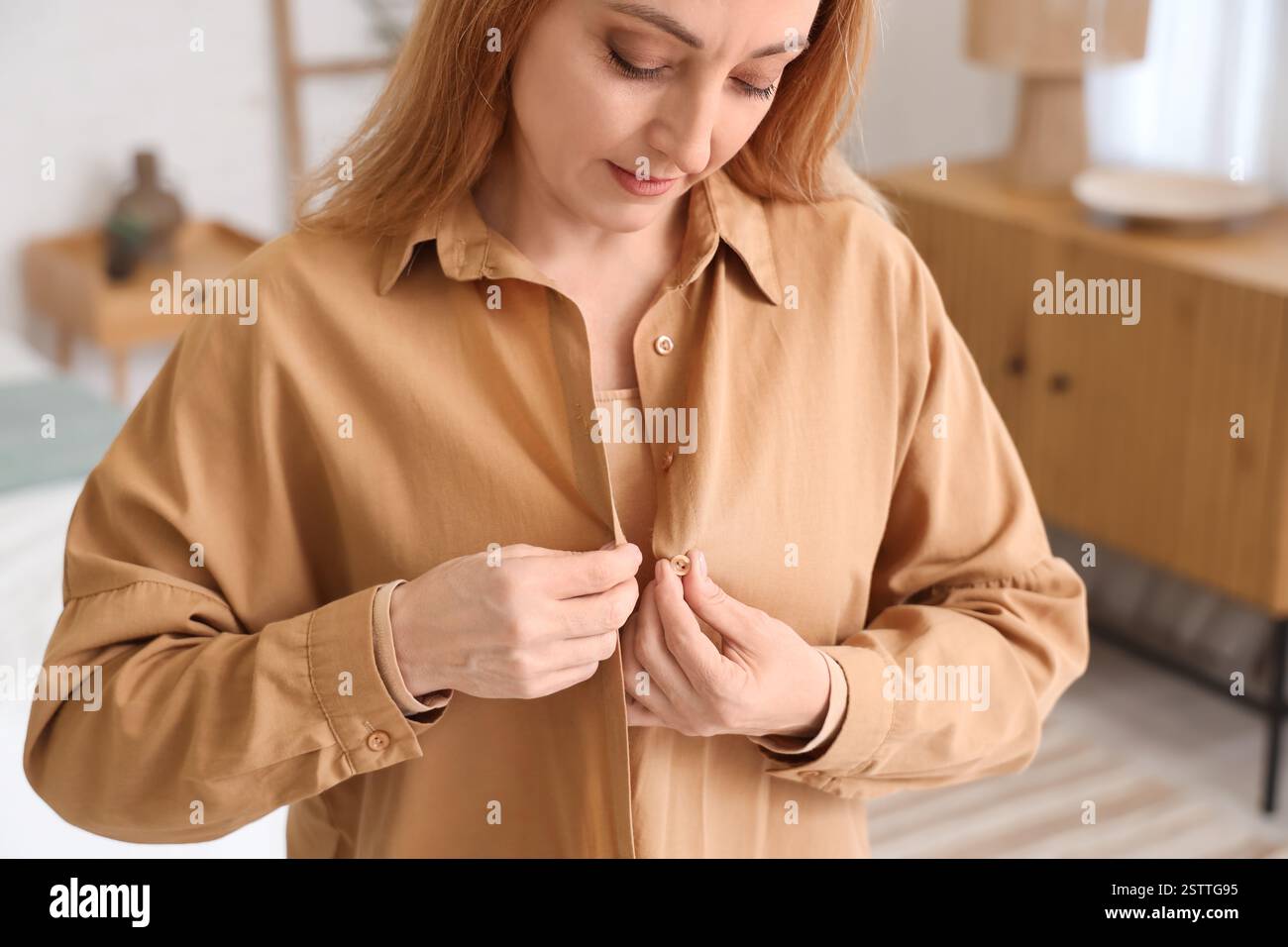 Mature woman buttoning up hi-res stock photography and images - Alamy