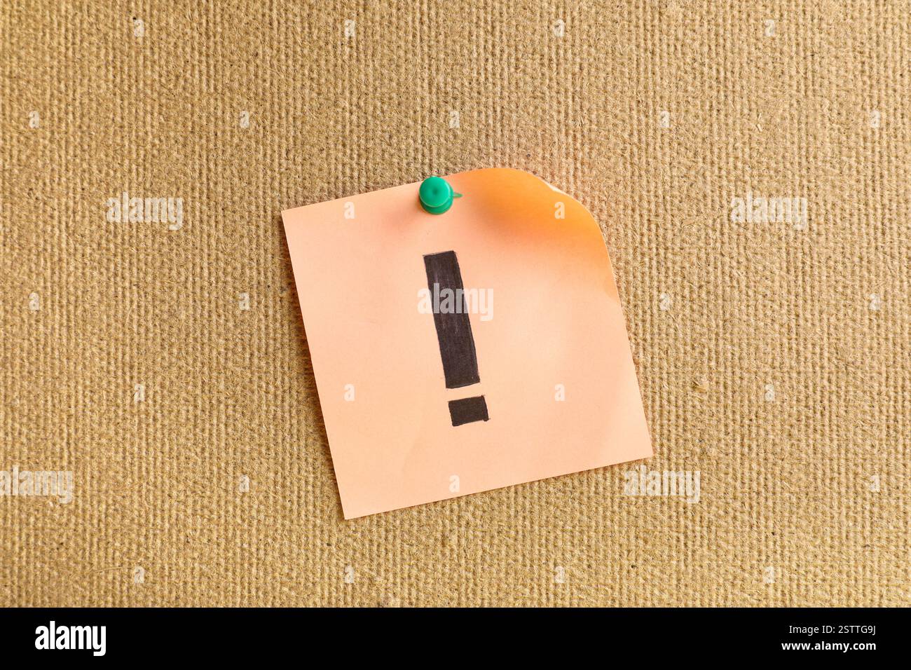 Sticky note with exclamation mark pinned on board Stock Photo - Alamy