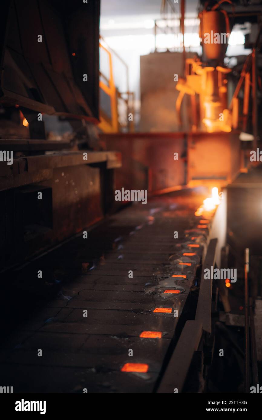 Molten metal flows along a conveyor belt in a metalworks factory Stock ...