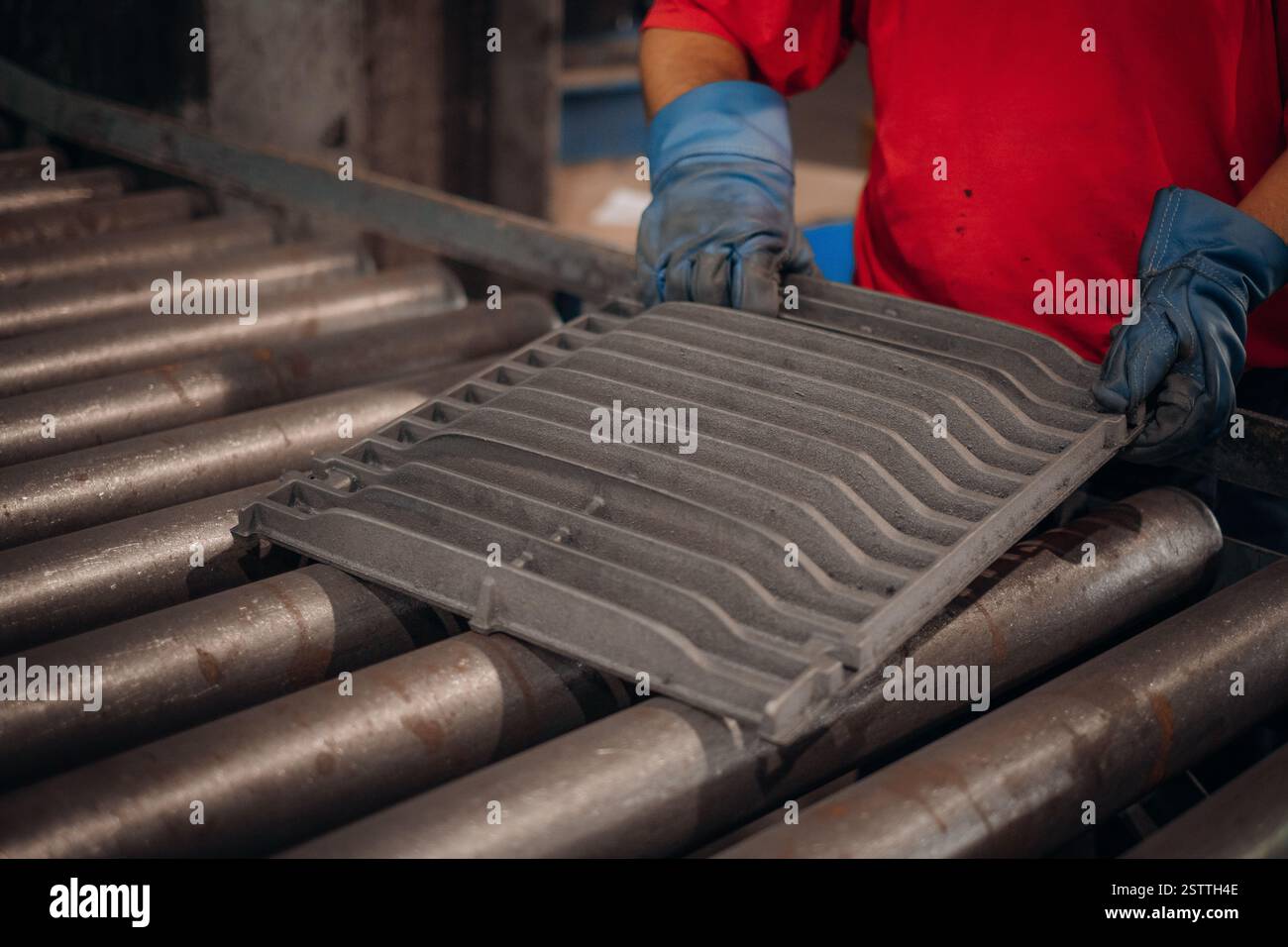 Industrial Worker Handling Metal Grate on Roller Conveyor Protective ...