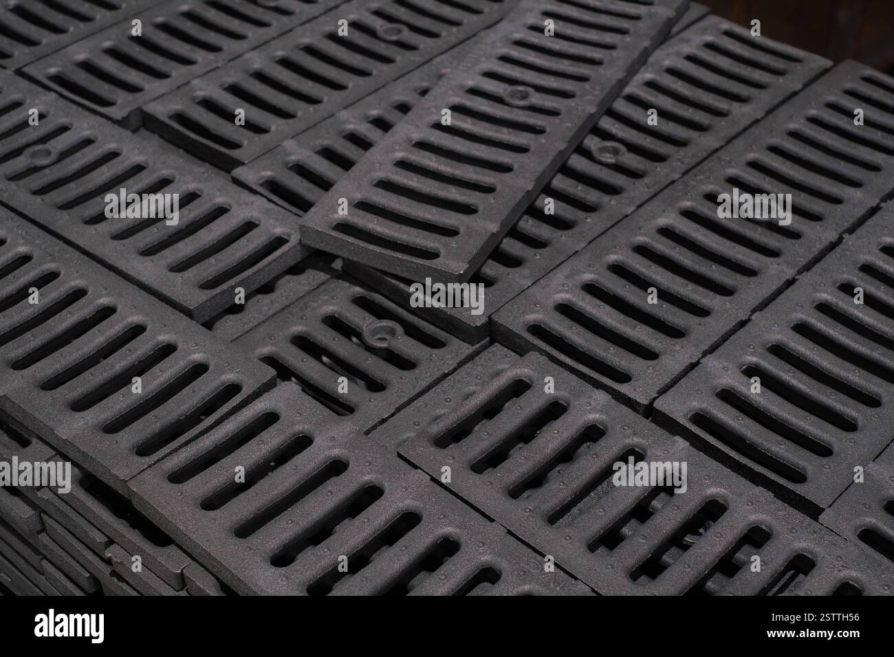 A stack of dark gray drainage grates ready for installation Stock Photo ...