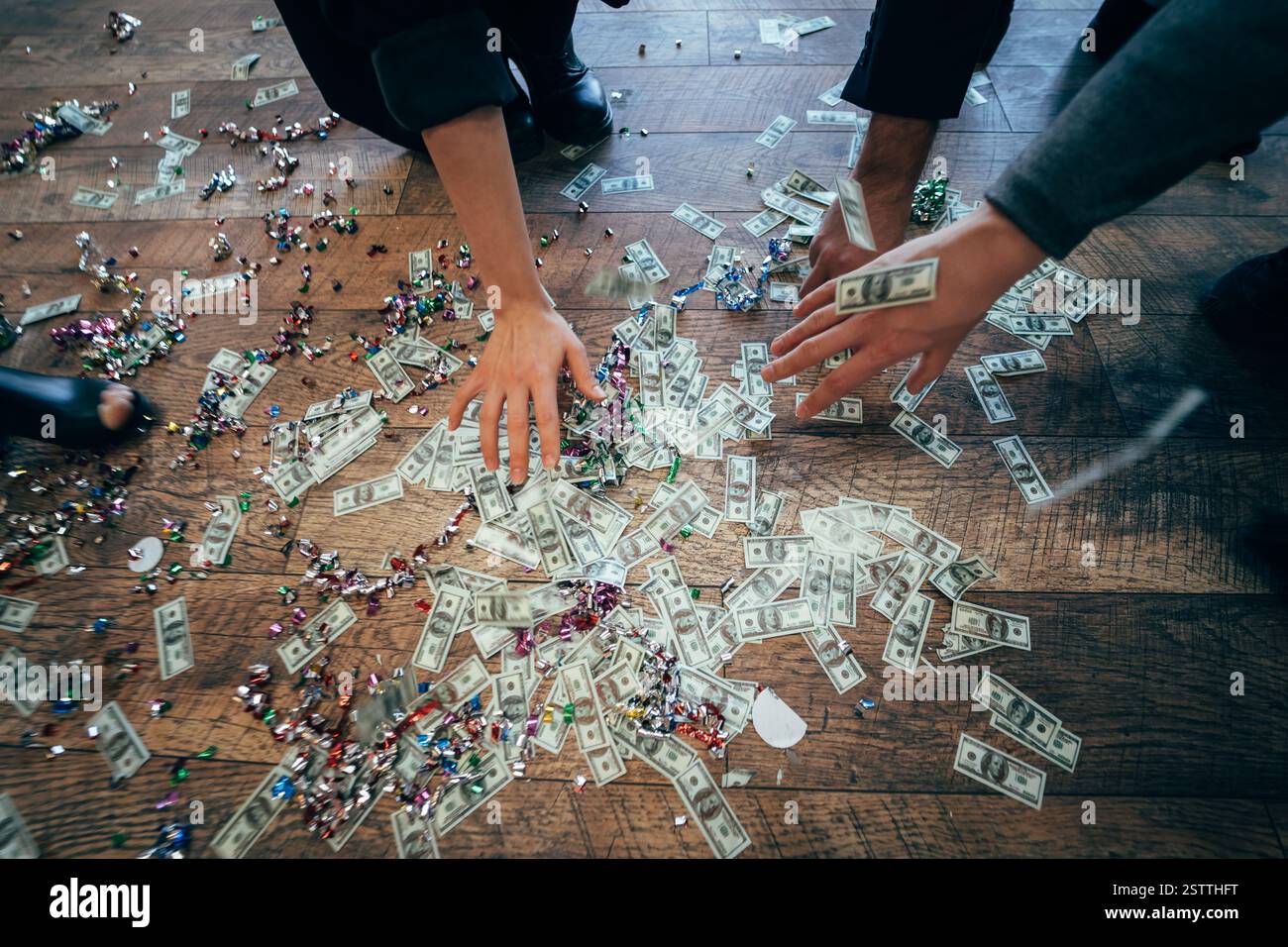Several pairs of hands pick up dollar bills from the floor Stock Photo ...