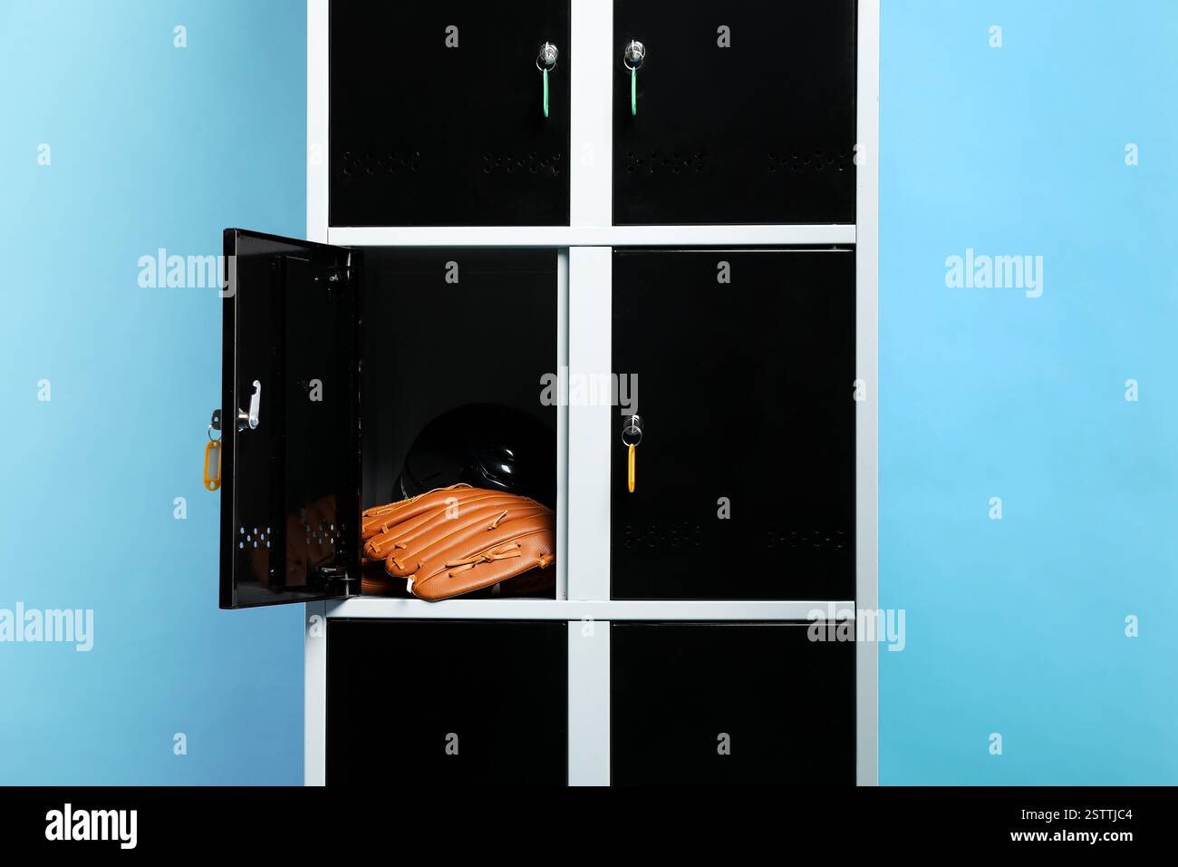 Open locker with baseball glove and helmet on light blue background ...