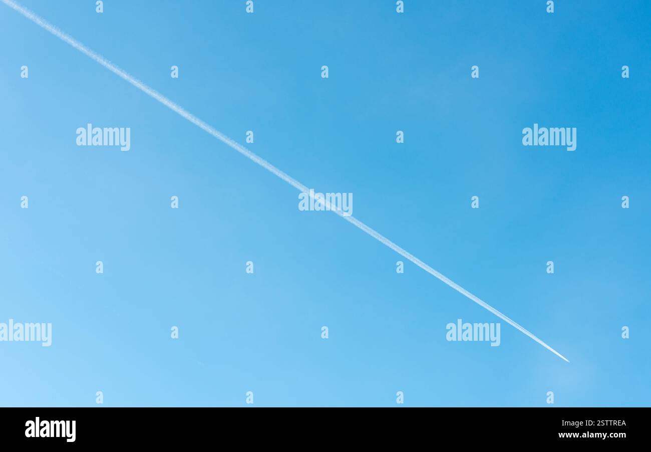 Jet plane flying and its contrail on blue sky Stock Photo - Alamy