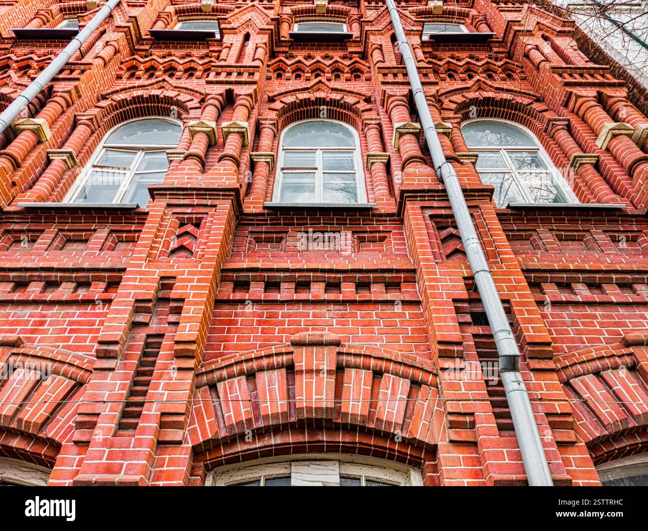 A look from below at the red brick building with tin drainpipes Stock ...