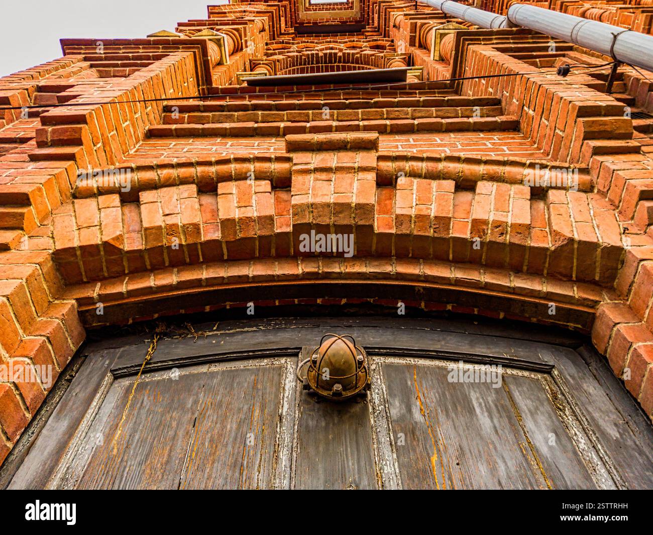 look from below at an old brick building with a fragment of a wooden ...