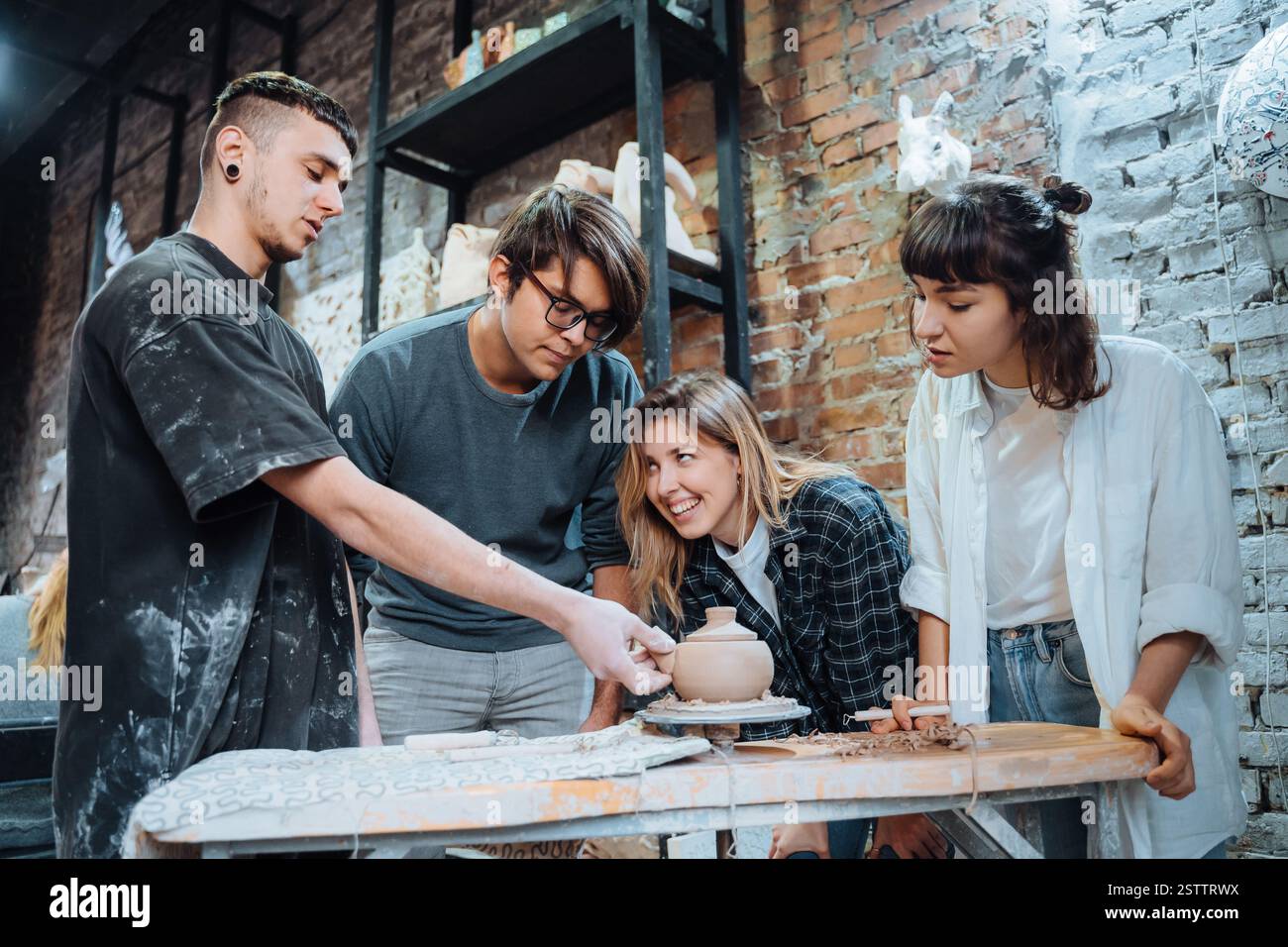 Pottery lesson on clay on a potter's wheel. Making a handmade clay pot ...