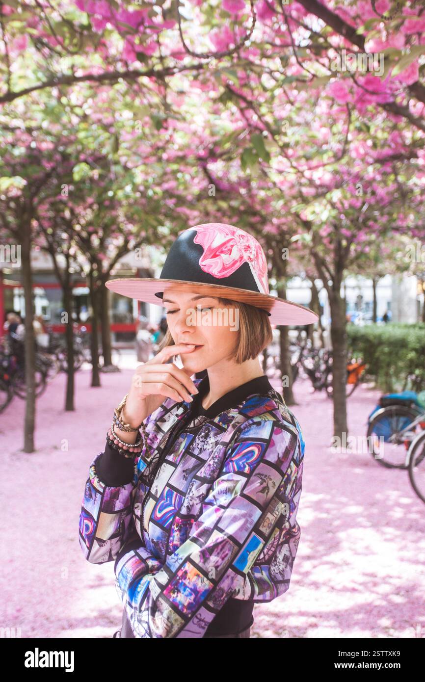 Beautiful woman wearing fashionable lila outfit and painted hat ...