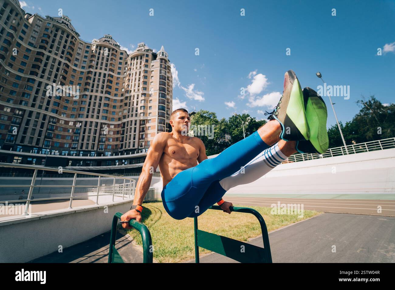 Strong man doing exercises on uneven bars in outdoor street gym Stock ...