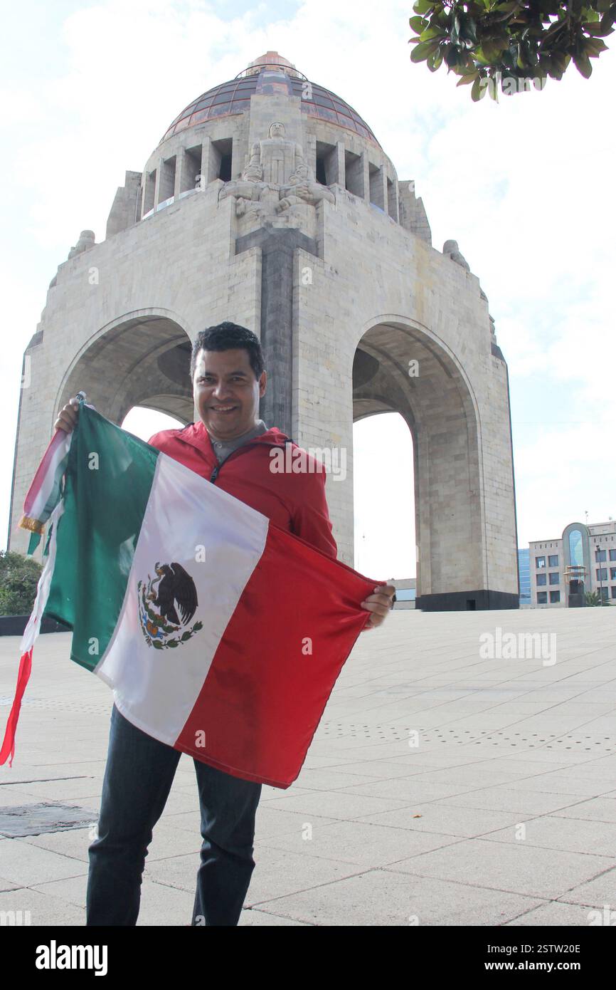 Latino adult man proudly displays the Mexican flag on the streets of ...