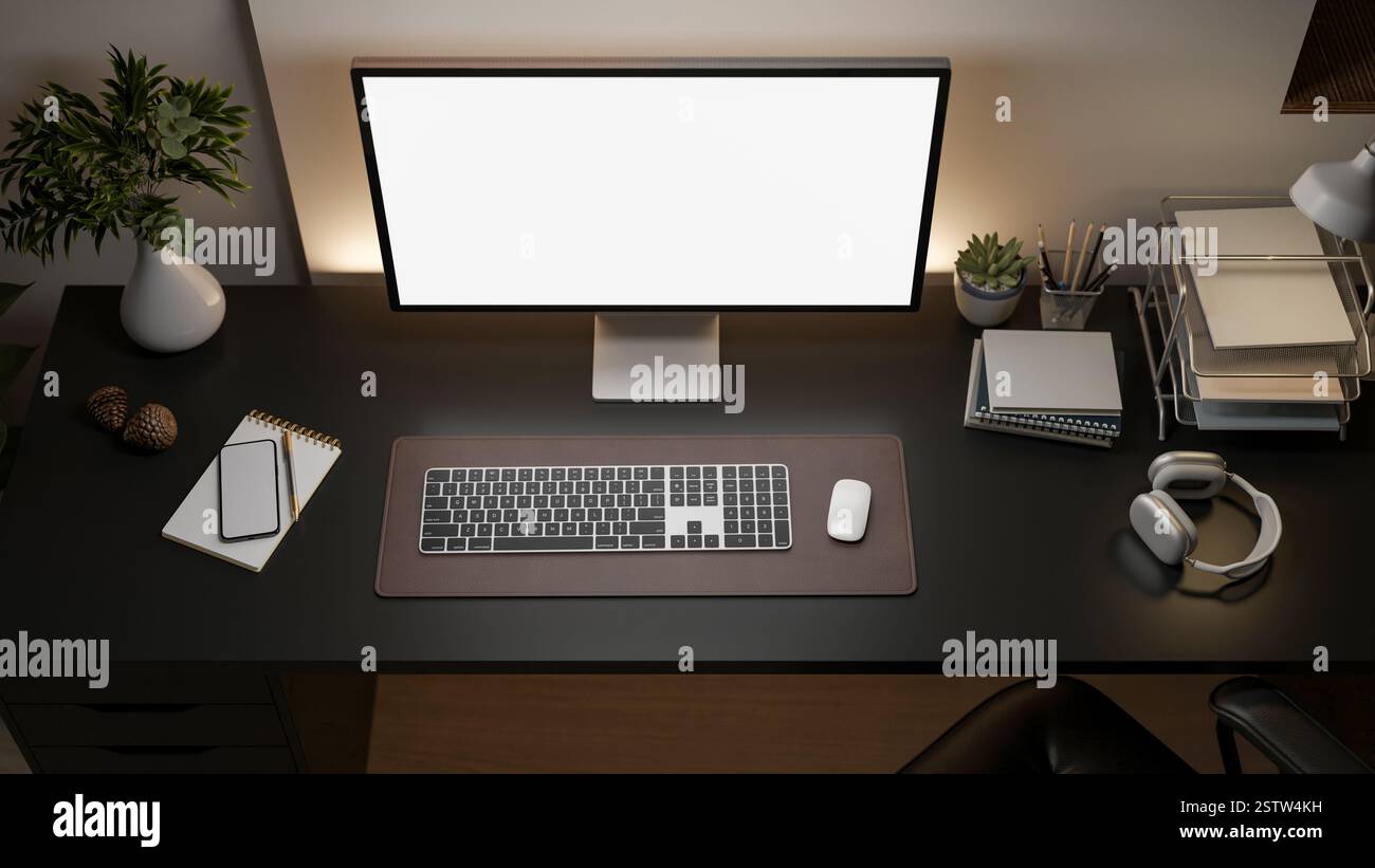 A white screen computer on the black wooden table with decorative items ...