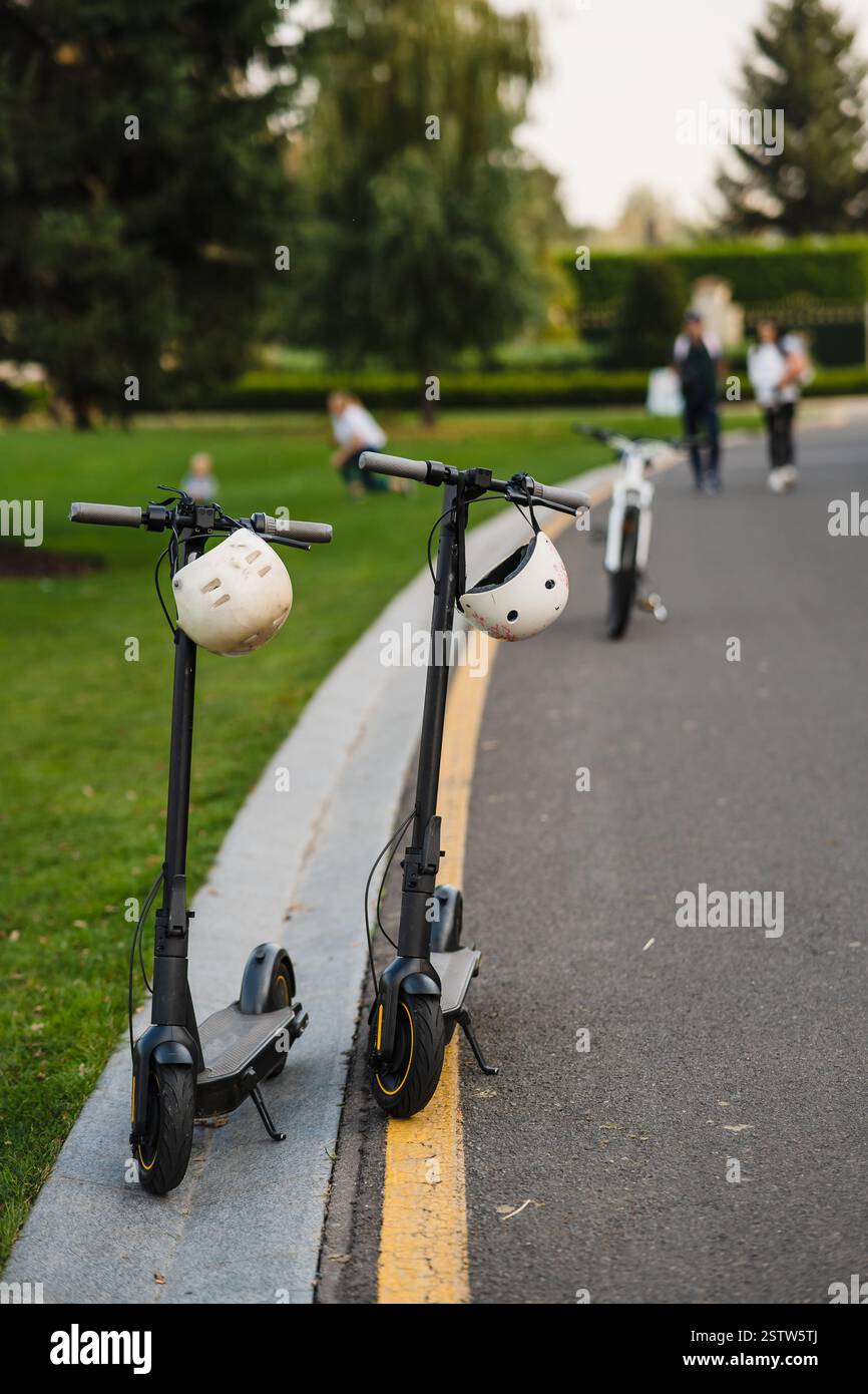 Two electric kick scooters or e-scooter parked on the sidelines road ...