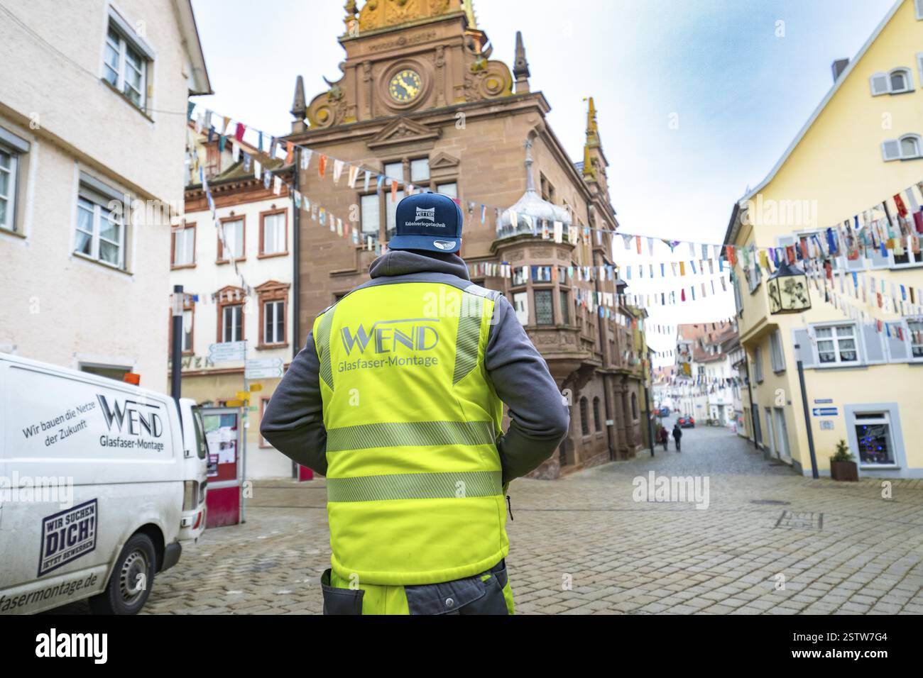 Workers in warning clothing on a cobblestone road, historical ...