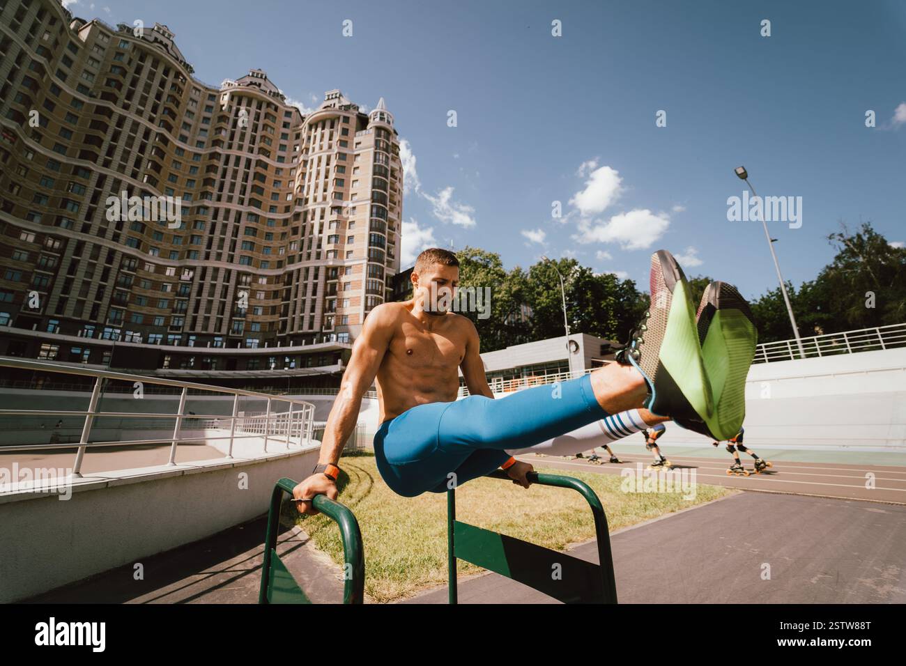 Strong muscular man doing exercises on uneven bars in outdoor street ...