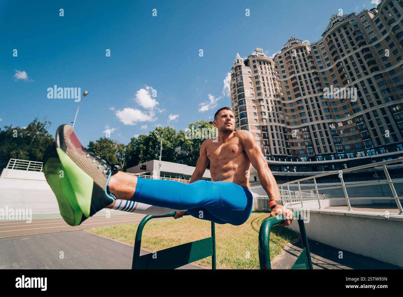 Strong man doing exercises on uneven bars in outdoor street gym Stock ...