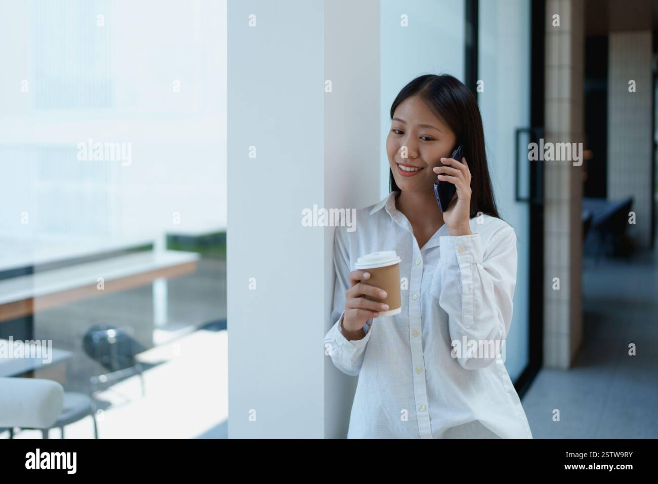 Woman engaged in a phone conversation, speaking on her cell phone with ...