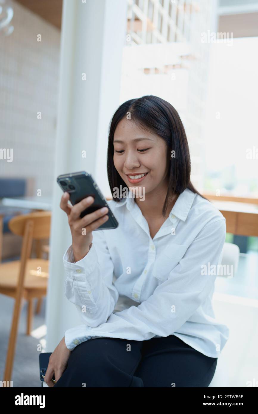 A thoughtful woman in casual attire sitting comfortably on a chair in a bright and inviting room ...