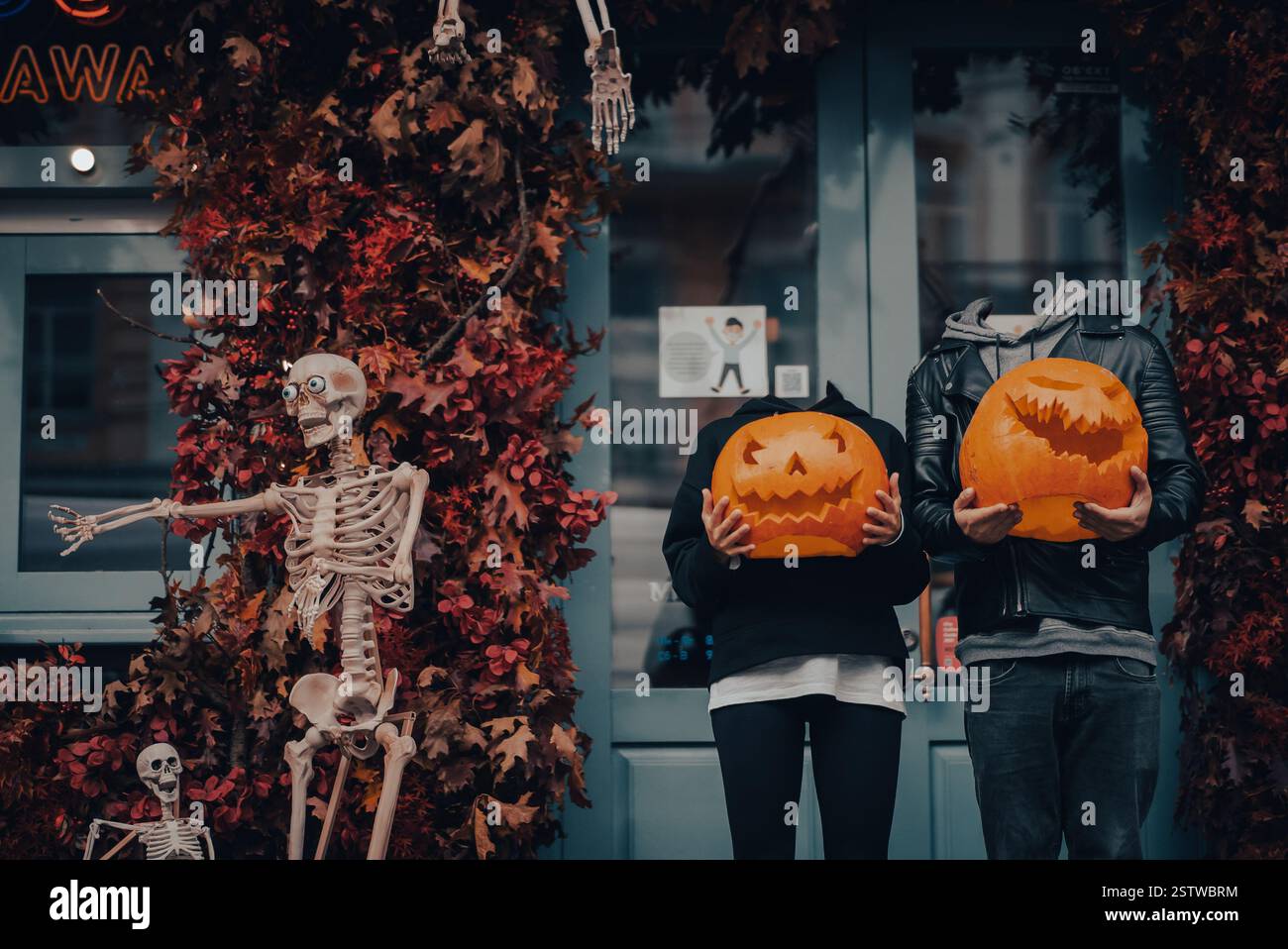 Headless couple holding pumpkin heads by the door on the street Stock ...