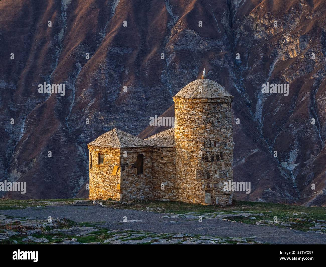 Stone mosque on the background of the mountains. The evening light ...