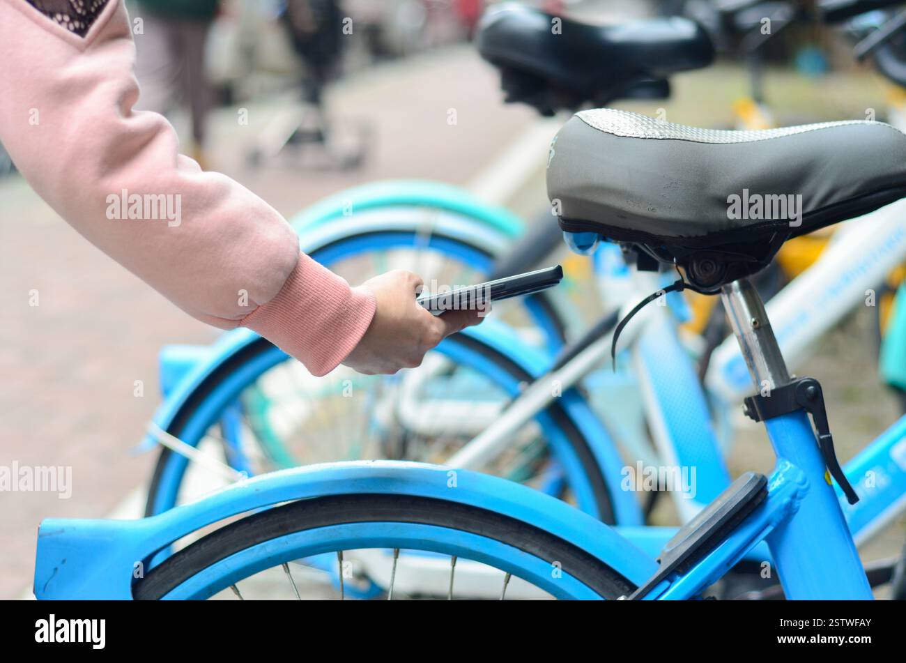 People use smart phone to scan the QR code on a shared bike to unlock ...