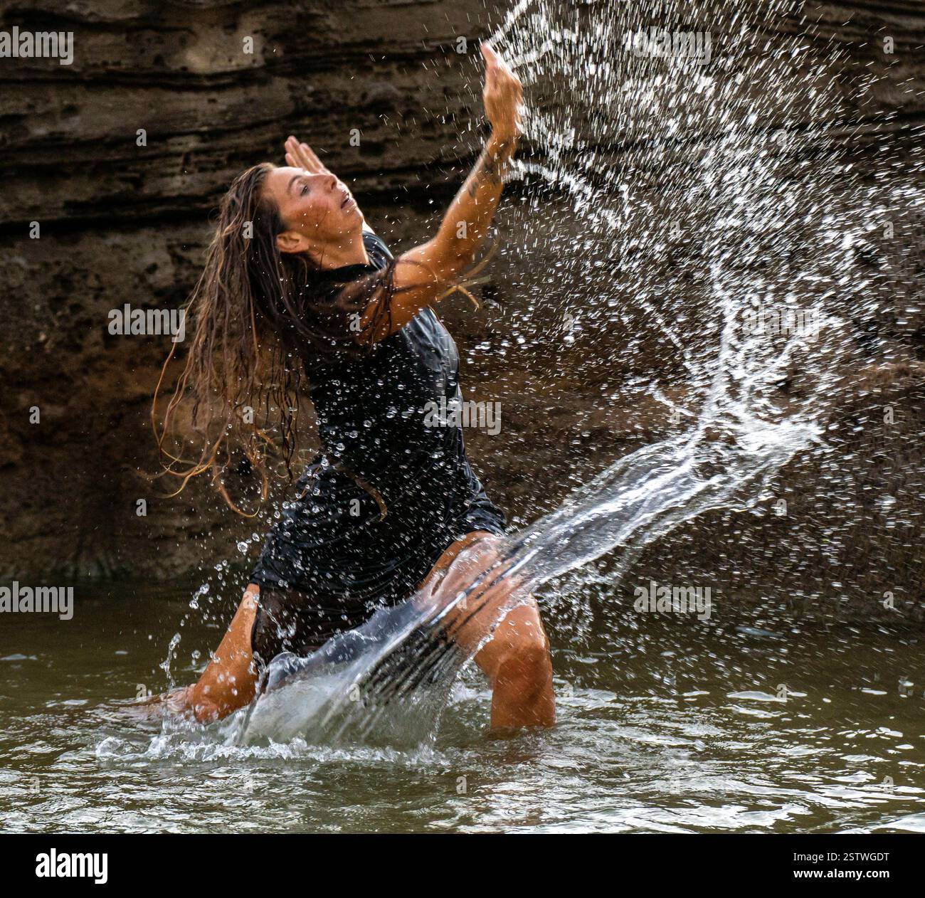 Middle-aged woman dancing and throwing water in the air Stock Photo - Alamy