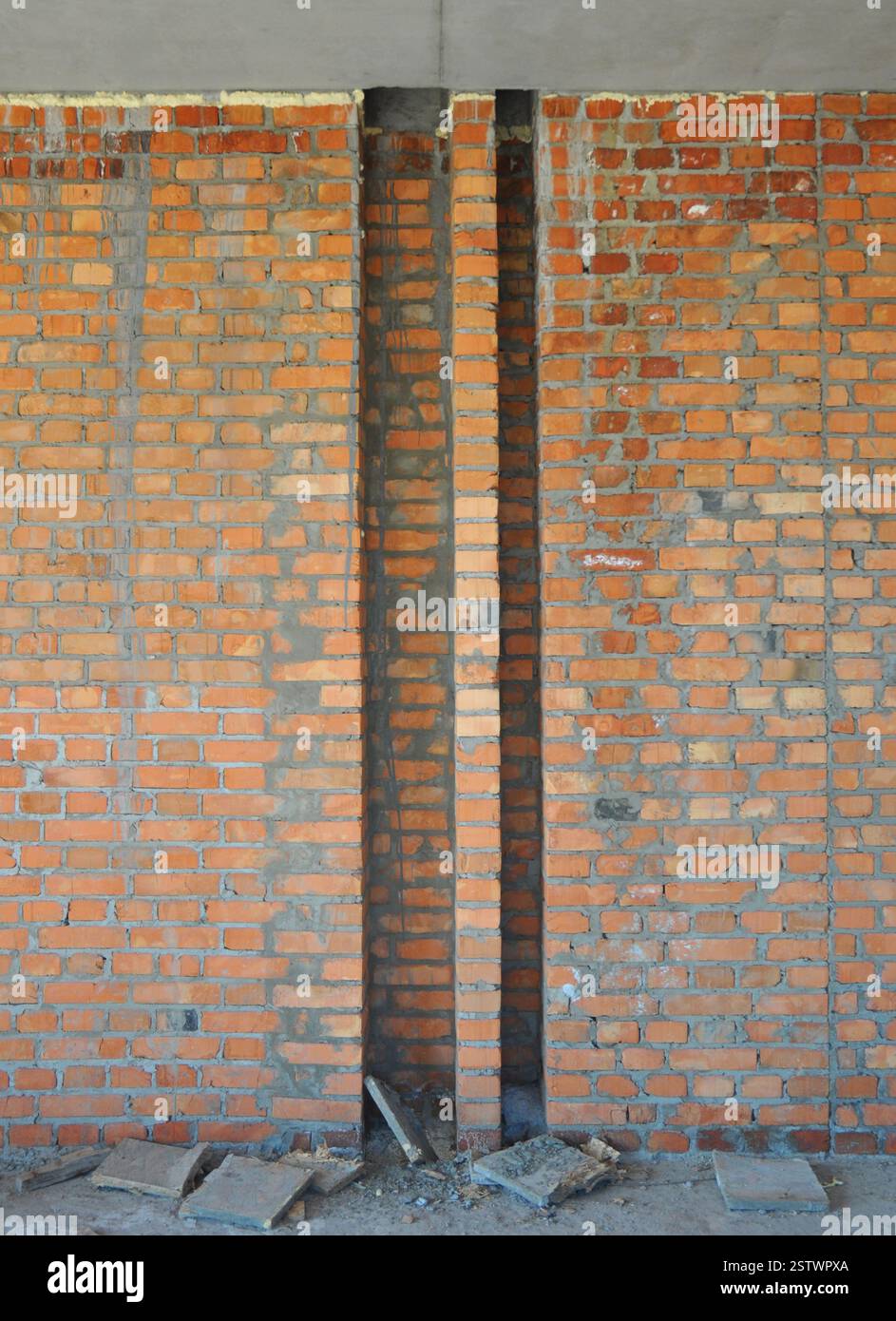 Ventilation and plumbing ducts in a brick wall inside a house being ...