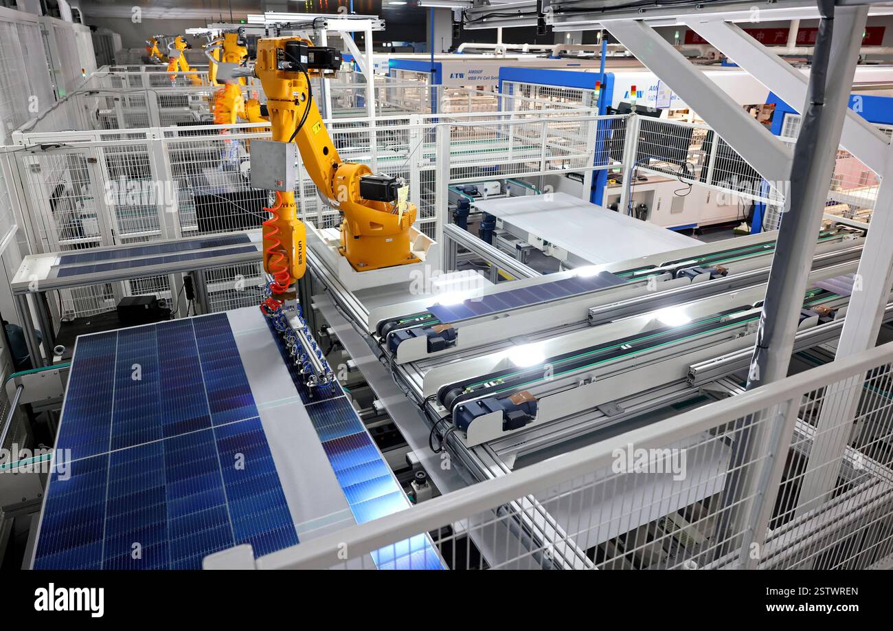 A robot arm produces photovoltaic modules at a solar energy production ...
