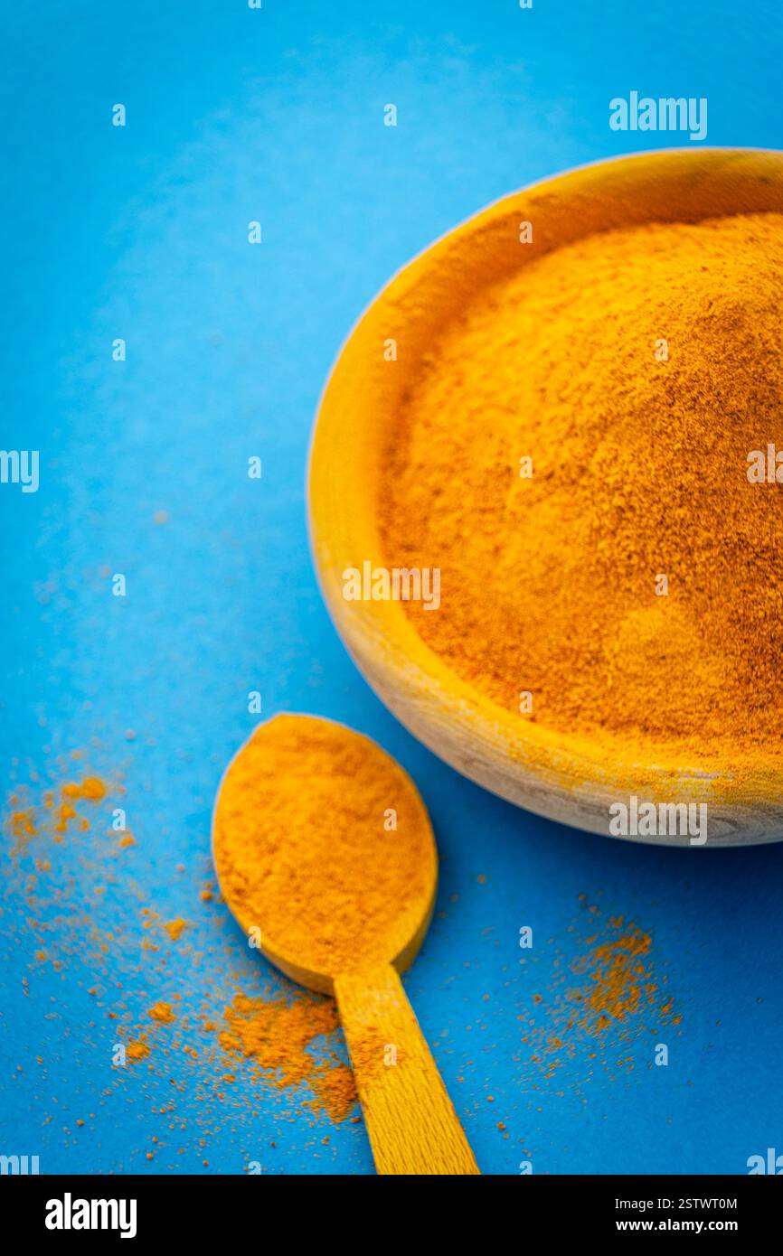 ground turmeric on blue background Stock Photo - Alamy