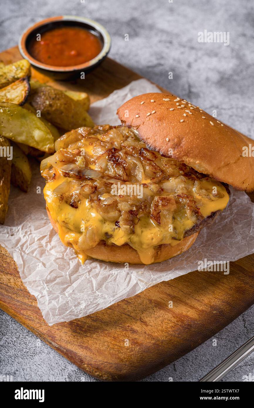Smash burger with cheddar cheese and caramelized onions, served with ...