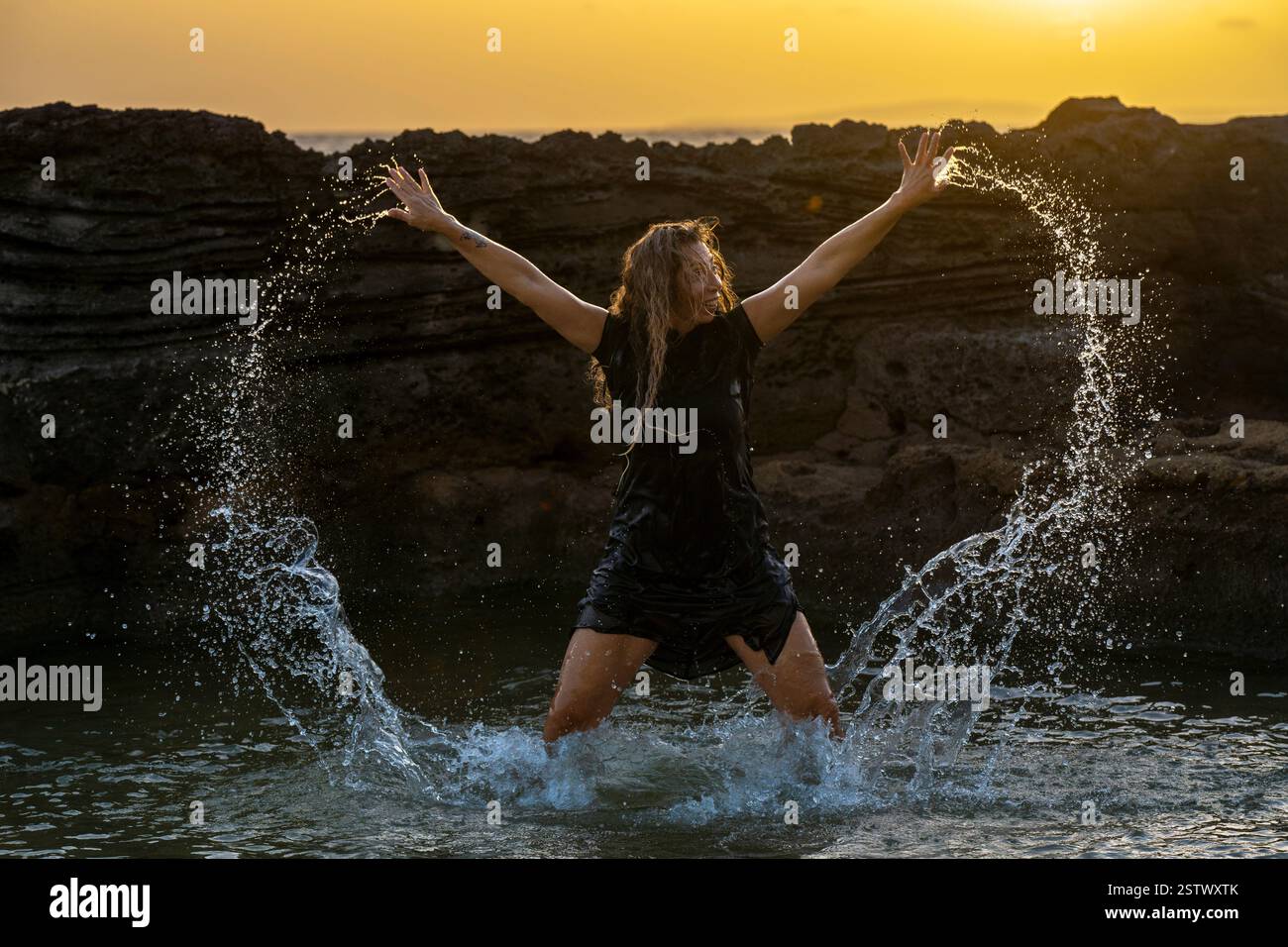 Middle-aged woman dancing and throwing water in the air Stock Photo - Alamy