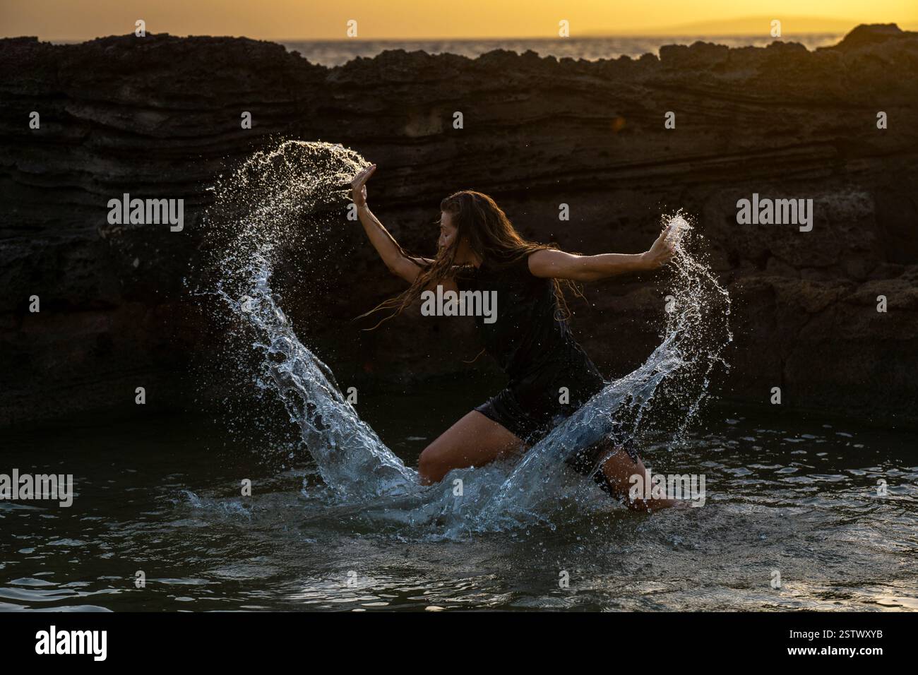 Middle-aged woman dancing and throwing water in the air Stock Photo - Alamy