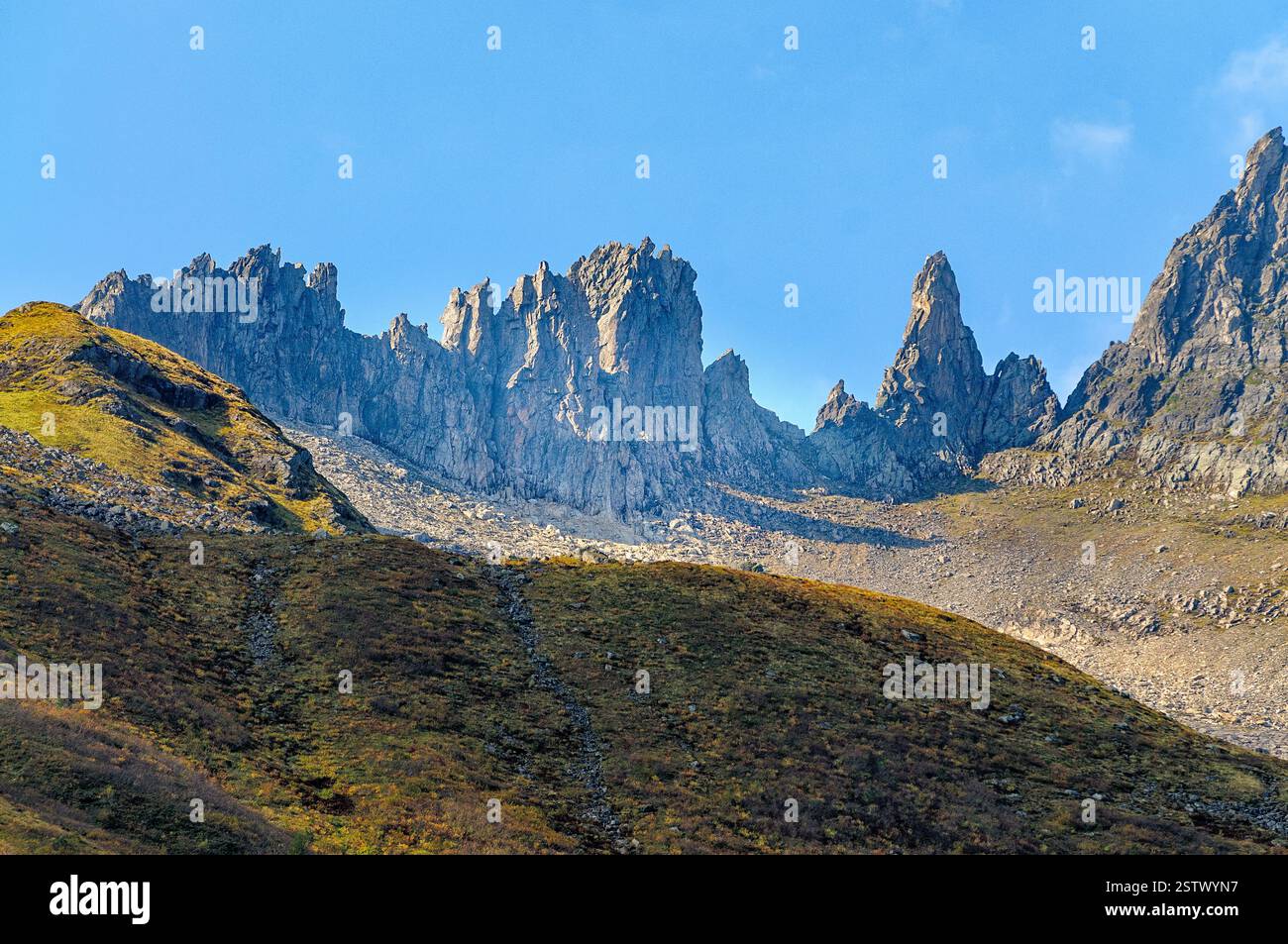 Stunning rock formations tower above rolling hills, bathed in sunlight ...