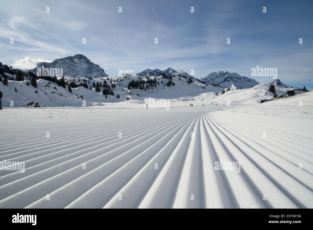 A freshly groomed ski slope in the Warth ski area in Lechtal with ...