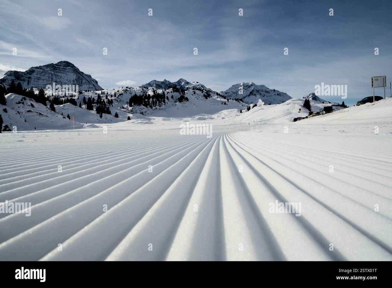A freshly groomed ski slope in the Warth ski area in Lechtal with ...